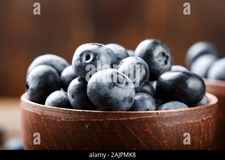 ripe blueberries in a clay plate on a brown wooden background. place ...