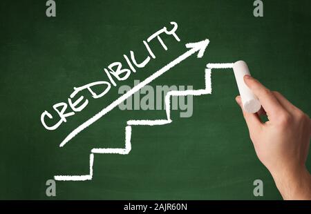 Hand drawing CREDIBILITY inscription with white chalk on blackboard ...