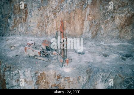 Open coal mine. Drilling machine borer installing cast explosives ...