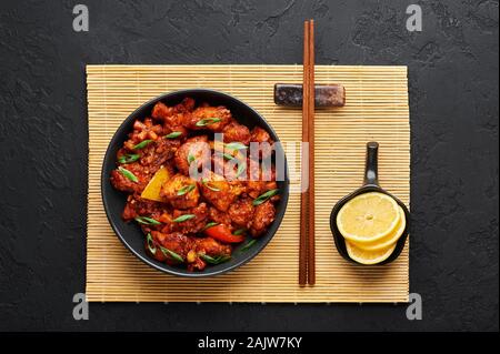 Fish Manchurian dry looks like Schezwan Fish in black bowl at dark ...