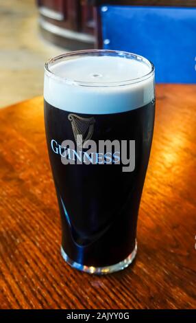 A pint of Guinness stout in a tall thin tulip glass Stock Photo - Alamy