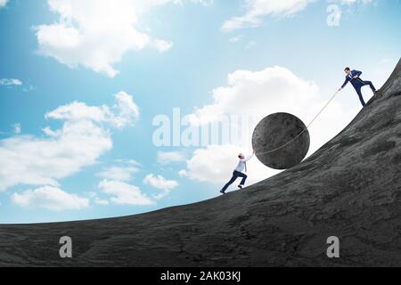 The team of people pushing stone uphill Stock Photo - Alamy