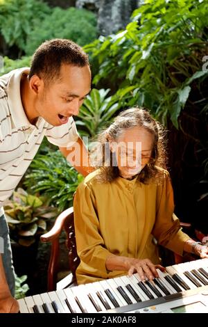 Man and woman singing son playing guitar and keyboard piano at music ...