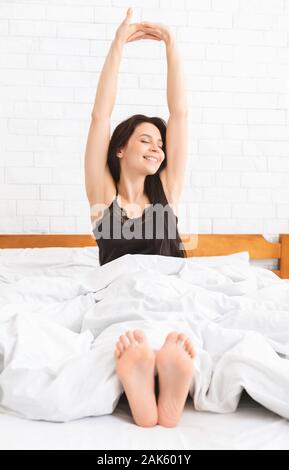 Girl slept well, wake up energized, sleepy stretching with closed eyes ...