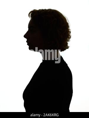 Black backlit silhouette of head and shoulders of an oriental woman ...