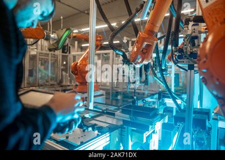 Man programming robot in automotive industrial, professional programmer ...