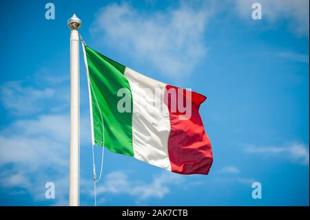 Italian flag blowing in the wind in the blue sky Stock Photo - Alamy