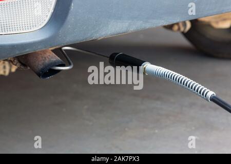 exhaust emissions test equipment being used during an MOT check for a ...