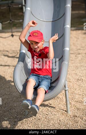 Child in red hat playing in snow on Christmas vacation. Winter outdoor ...