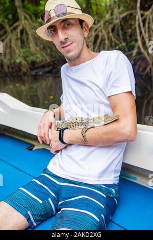 Baby crocodile in human hands Stock Photo - Alamy