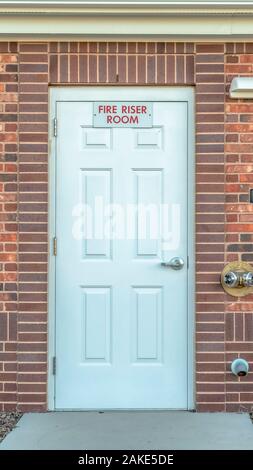 Fire Riser Room sign on the white wood door of a building with red ...