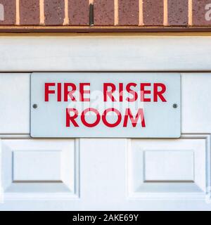 Square frame Fire Riser Room sign on the white wood door of a building ...