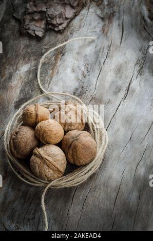 Walnuts on aged wood with twine. Closeup Stock Photo - Alamy