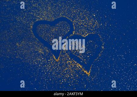 Two hearts made of golden glitter and stars on a pink background ...