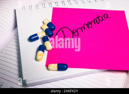 Writing Dementia on memo post reminder and medicines, pills. Writing ...