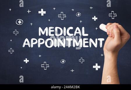 Hand drawing MEDICAL APPOINTMENT inscription with white chalk on ...