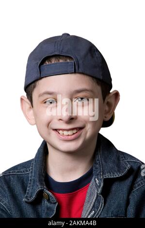 A boy with a baseball hat on backwards plays a football game with his ...