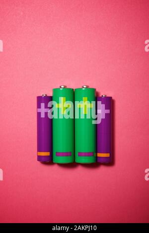 Small batteries on a pink table Stock Photo - Alamy