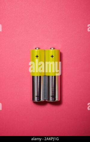 Small batteries on a pink table Stock Photo - Alamy