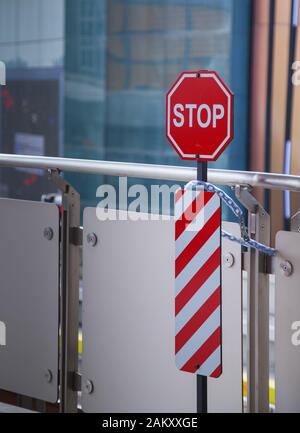 Vertical red and white striped caution road signs stand in a row to ...