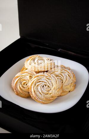 Round shortbread cookies in the form of roses. On a white plate Stock ...