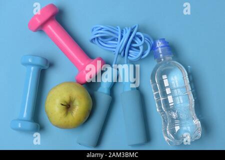 Jump rope, apple and barbells next to water bottle Stock Photo - Alamy