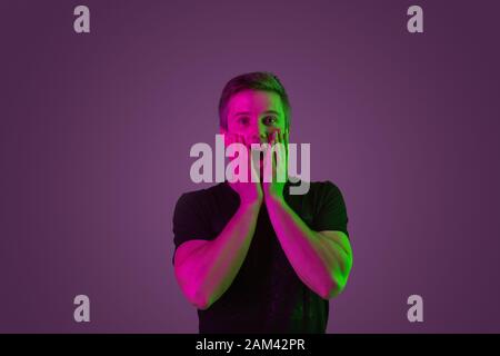 Caucasian man's portrait on purple blue studio background in ...