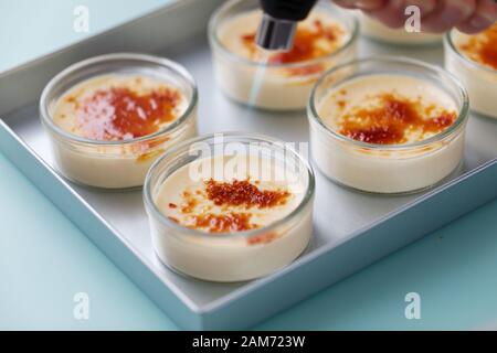 Caramelizing Creme Brulee Using a Torch Stock Photo - Alamy