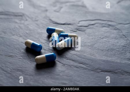 Sports Supplements (creatine capsules) on dark stone background. Close ...