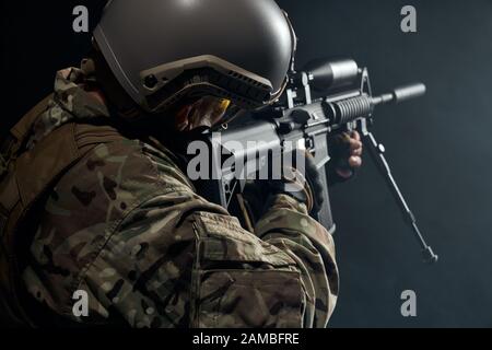 Side view of old military officer holding sniper rifle and aiming ...