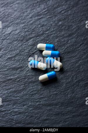 Sports Supplements (creatine capsules) on dark stone background. Close ...