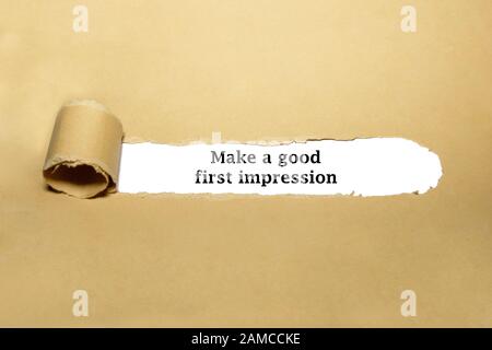 The text Make a good first impression appearing behind torn brown paper ...
