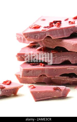 ruby chocolate bar with colorful chocolate candy tablets on pink ...