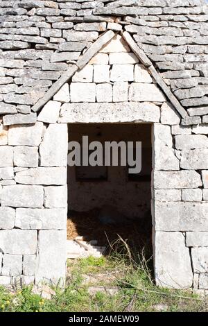 Trullo house with entrance, traditional old houses and old stone wall ...
