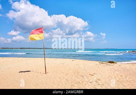 Tropical beach with red and yellow flag, Sri Lanka Stock Photo - Alamy