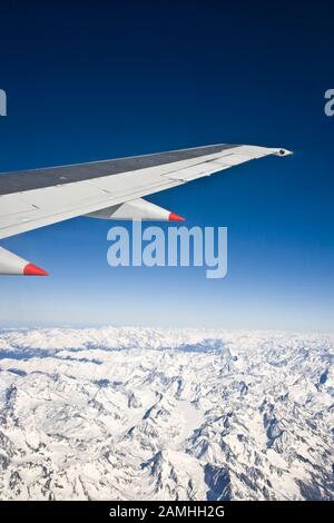 airplane wing flying over snow capped mountains Stock Photo - Alamy