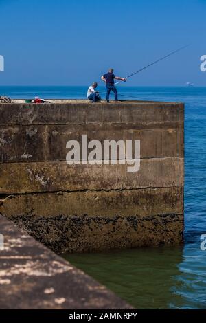 PORTO, PORTUGAL - MAY, 2018: Men fishing at the beautiful Porto coast ...