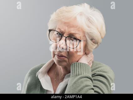 Old lady suffering with neck pain, she is touching her neck, healthcare ...