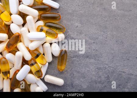 Tablets, pills, capsules, drugs pouring out of white bottle on white ...