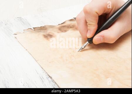 Male hand with pen writes on old paper Stock Photo - Alamy