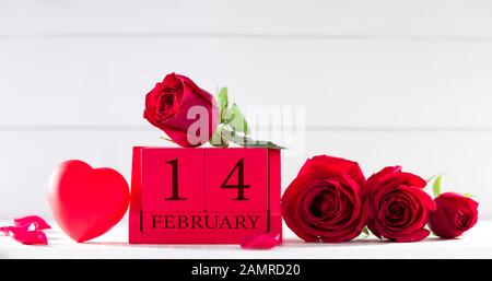 Cube calendar with date 14 FEBRUARY and red rose flowers on light ...