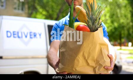 Express delivery service worker in medical mask with big food bag and ...
