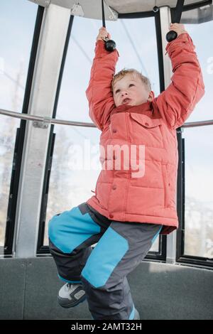 Boy standing in an overhead cable car holding onto a railing, Mammoth ...