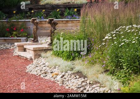 Rock edged red cedar mulch path and borders with yellow Hemerocallis ...