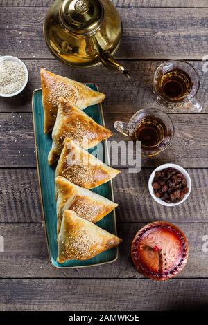 Delicious samosas samsa with meat, glass of tea on wooden table ...