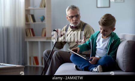 Angry old grandpa shouting at grandson close ears ignore grandfather ...