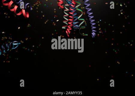 Carnival objects on a black background. Chinese fans, Coiled streamers ...