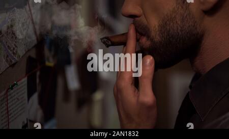 Male cop with cigar analyzing information of crime on investigation ...