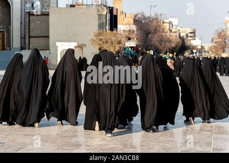 Iranian women, dressed in black burqas / burkhas, walking in street ...