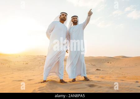 Two business men wearing traditional uae white kandura spending time in ...